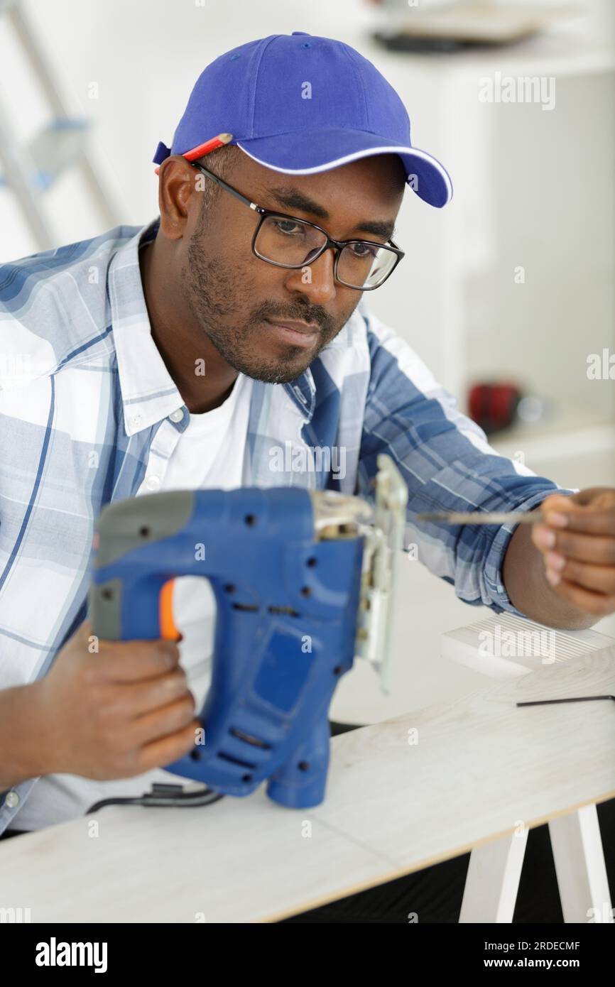 man fixing the blade in an electric jigsaw tool Stock Photo - Alamy