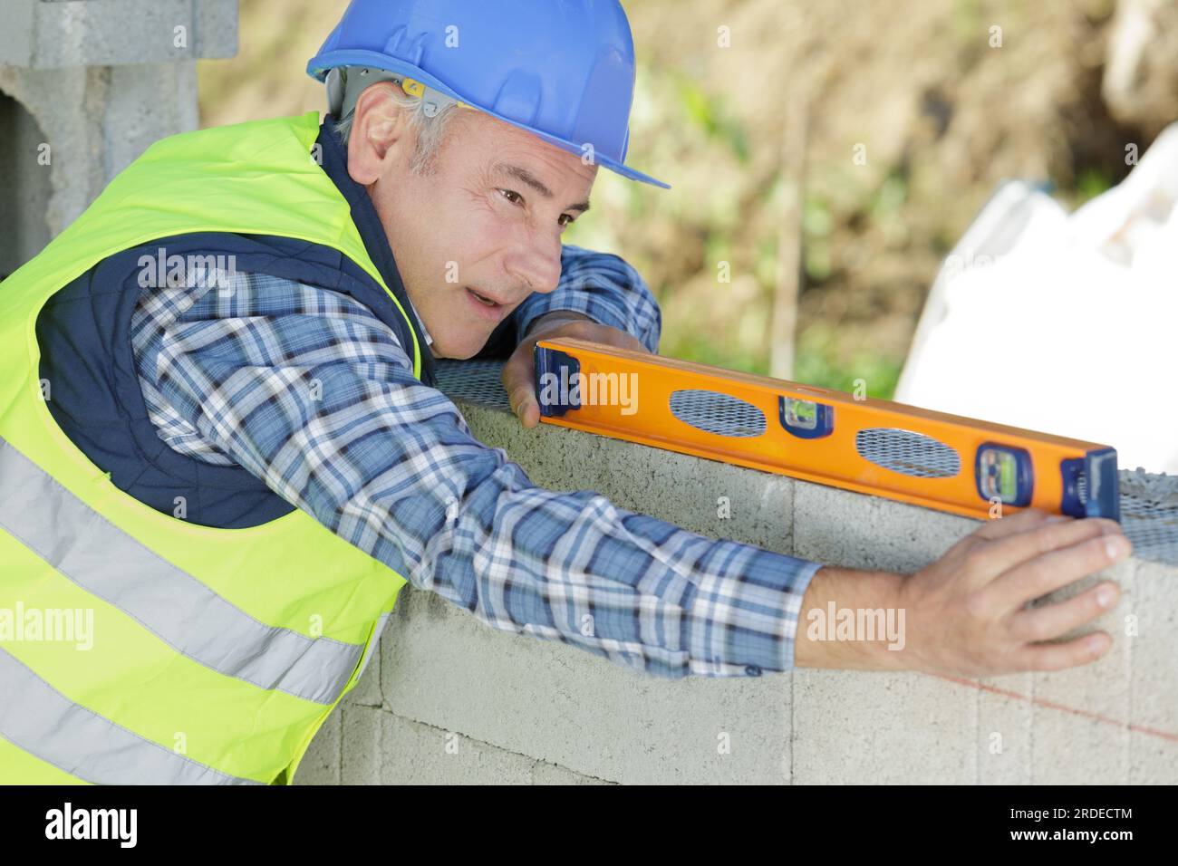 male builder using a level on wall Stock Photo - Alamy