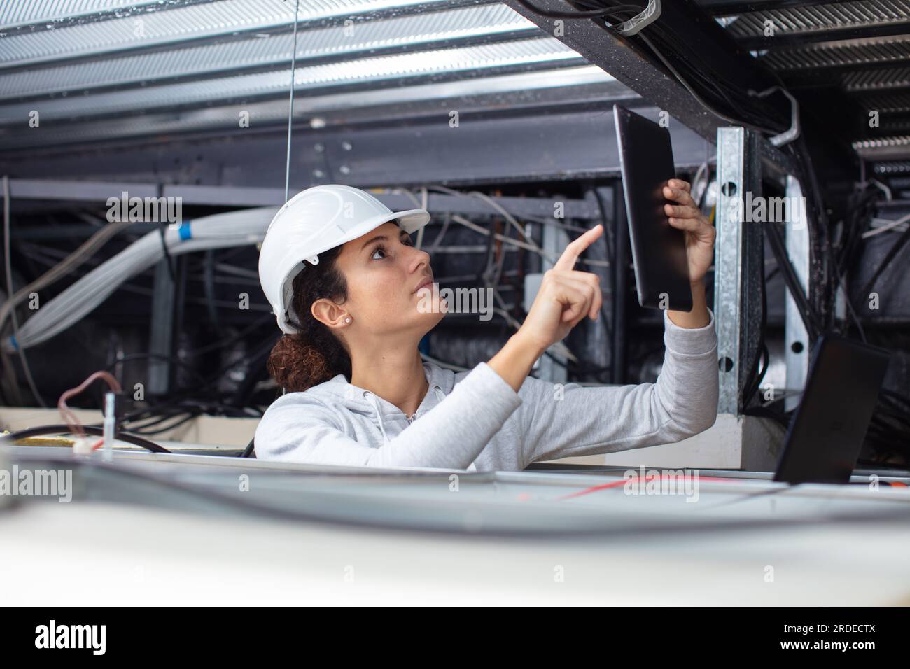 female electrician checking her tablet Stock Photo - Alamy