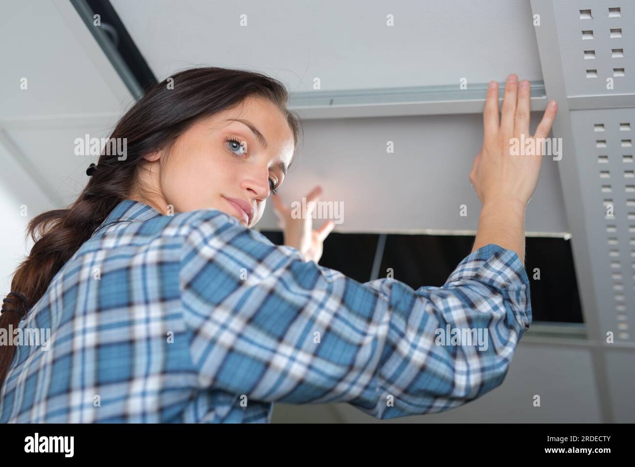 female construction worker fixing roof problem Stock Photo - Alamy