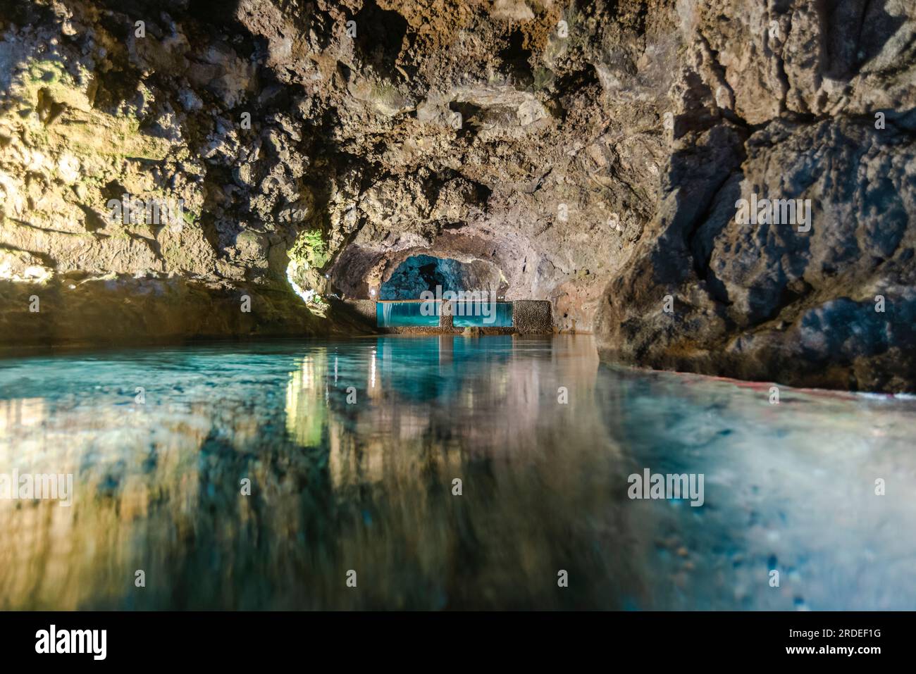 artificial light reflections in underground lake inside volcanic cave ...