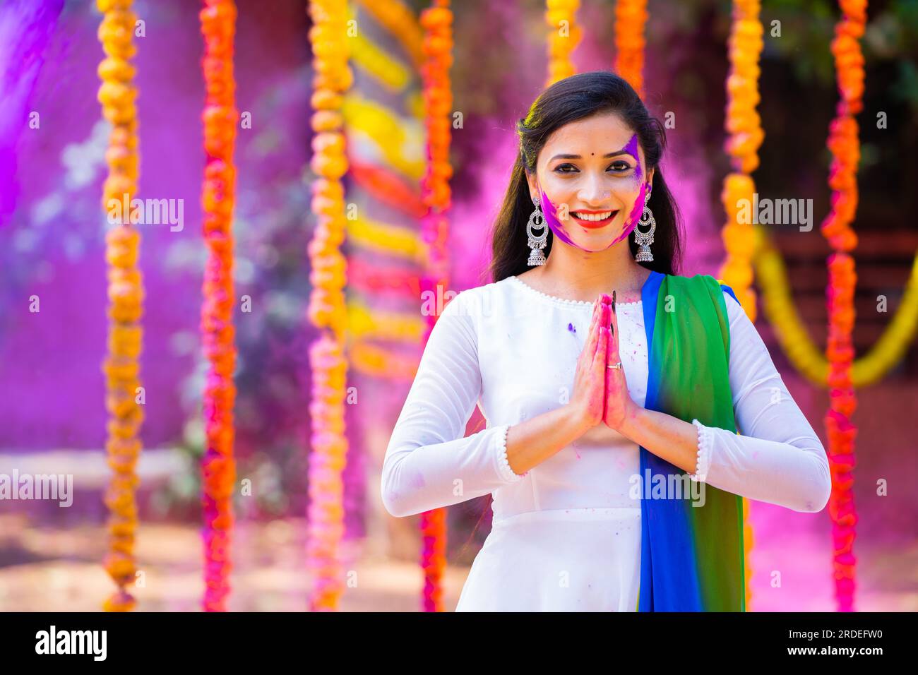 Happy young colorful girl showing namaste or holi gesture by looking ...