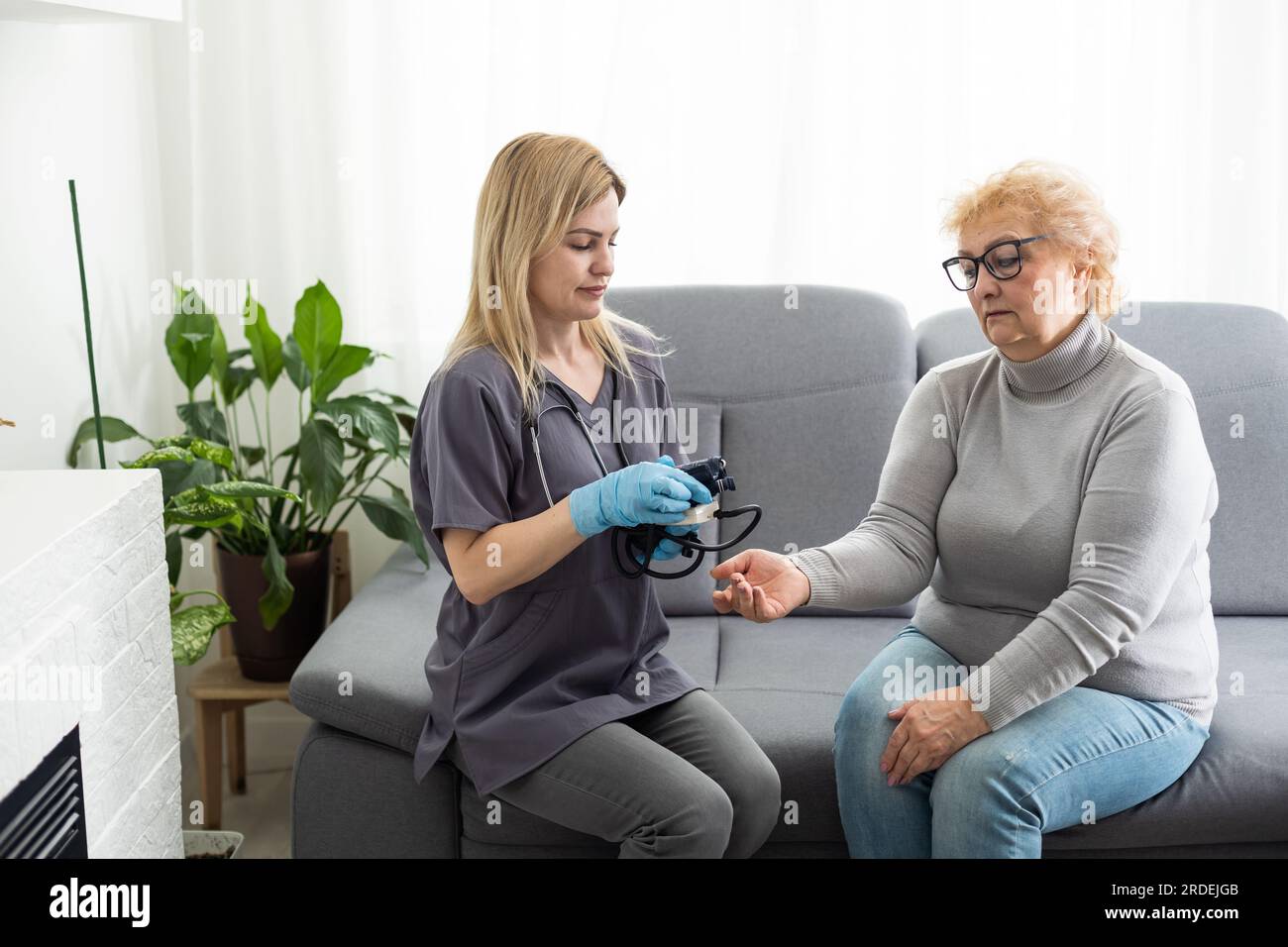 Caring young nurse doctor carer helping holding hands of happy disabled ...