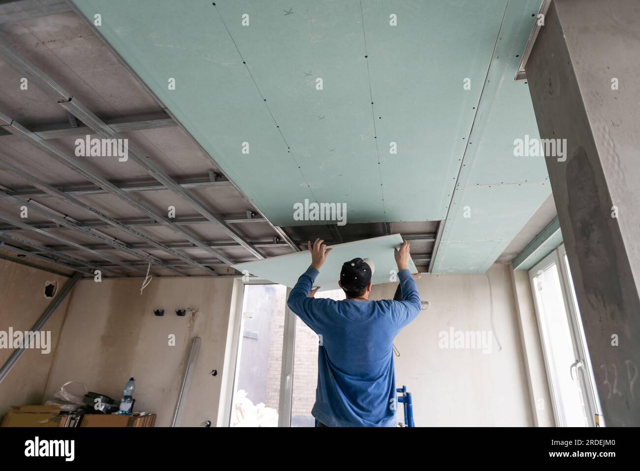 Drywall Installers. Men holding a gypsum board figured cut Stock Photo ...