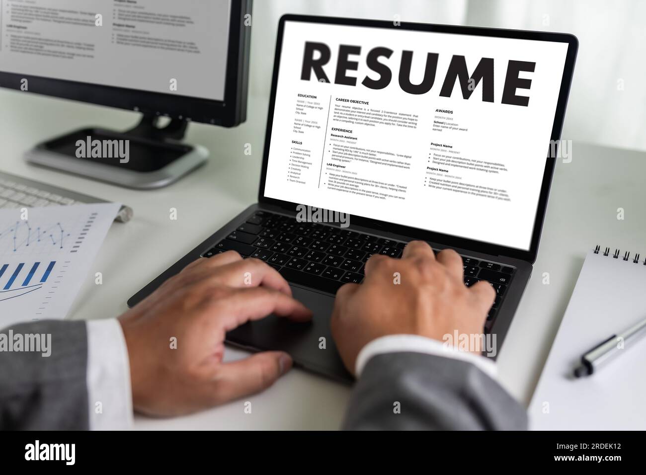 Businessmen Reading Resumes for a new job use laptops and CVs in the ...