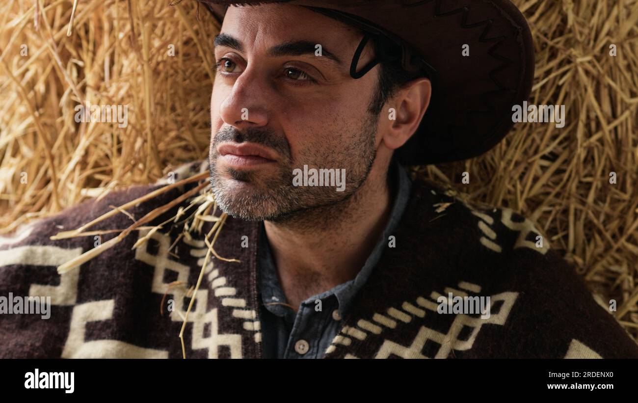 Pensive cowboy on hay Stock Photo - Alamy