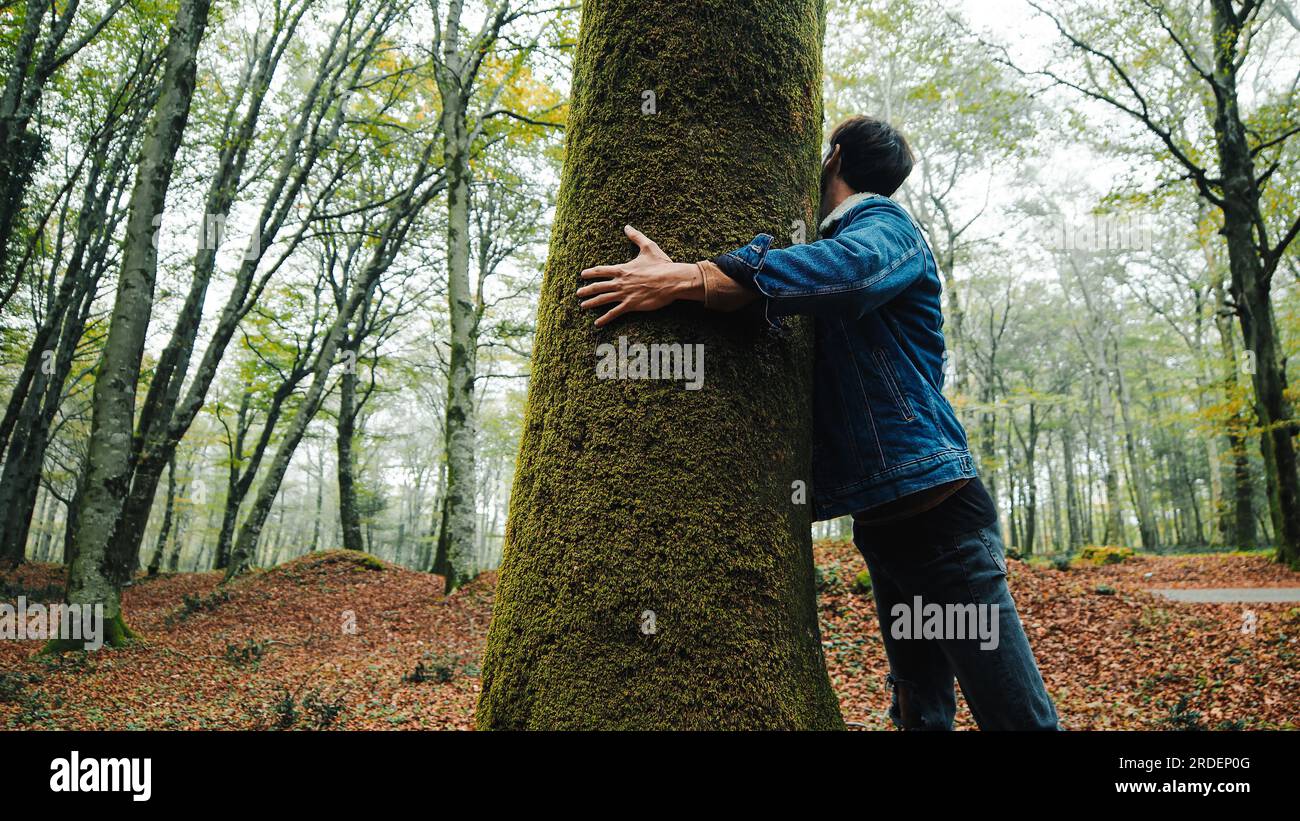 Boy hugs tree trunk. Love for nature Stock Photo - Alamy