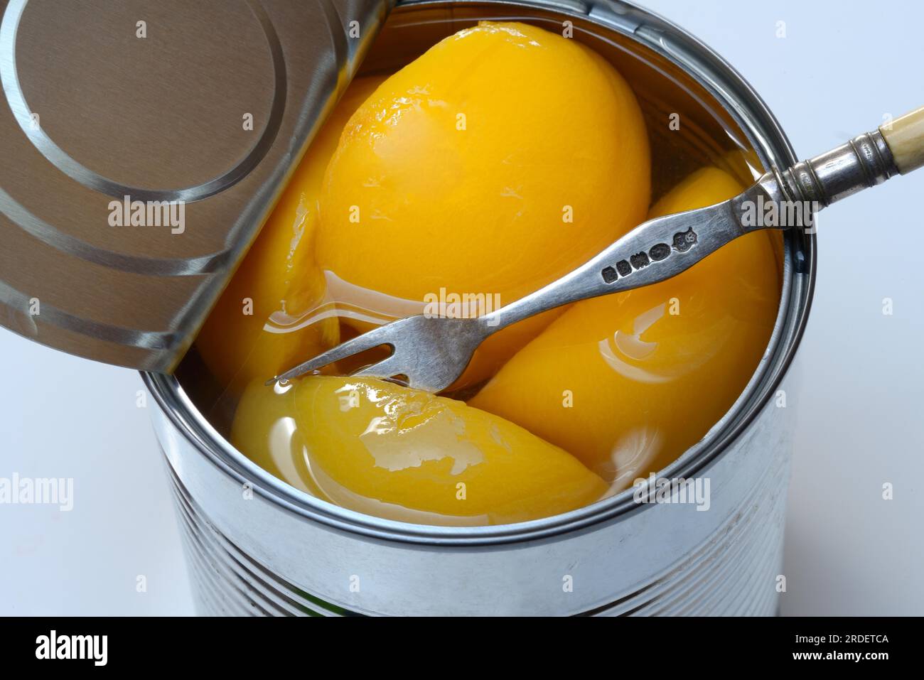 Peach, preserved peach halves with syrup in a tin can Stock Photo - Alamy