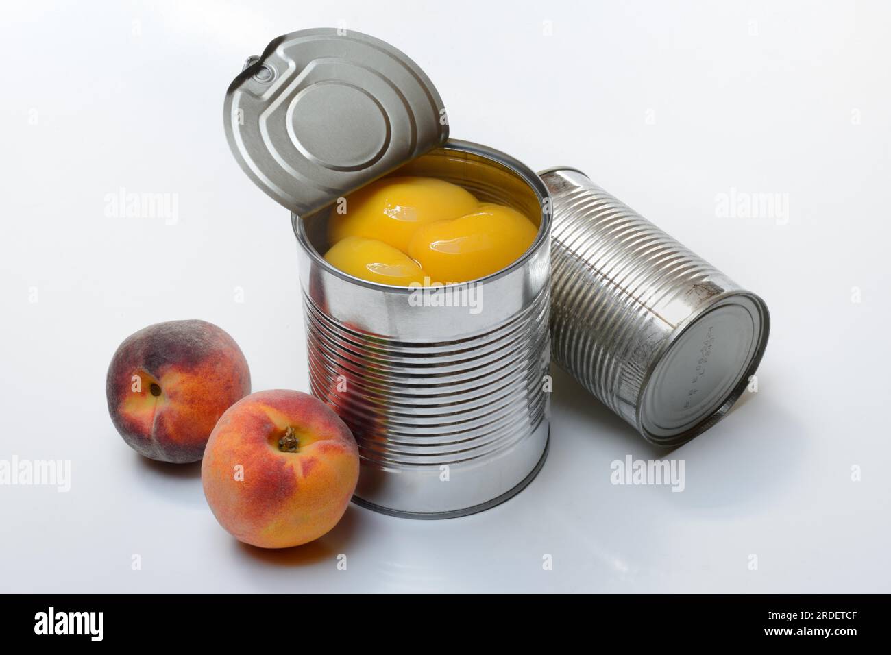 Peach, preserved peach halves with syrup in a tin can Stock Photo - Alamy