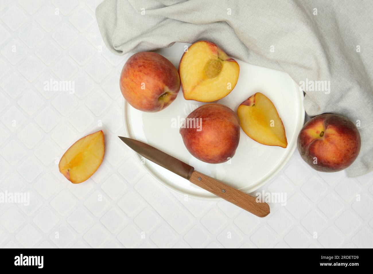 Cut peaches with knife on plate (Prunus persica Stock Photo - Alamy