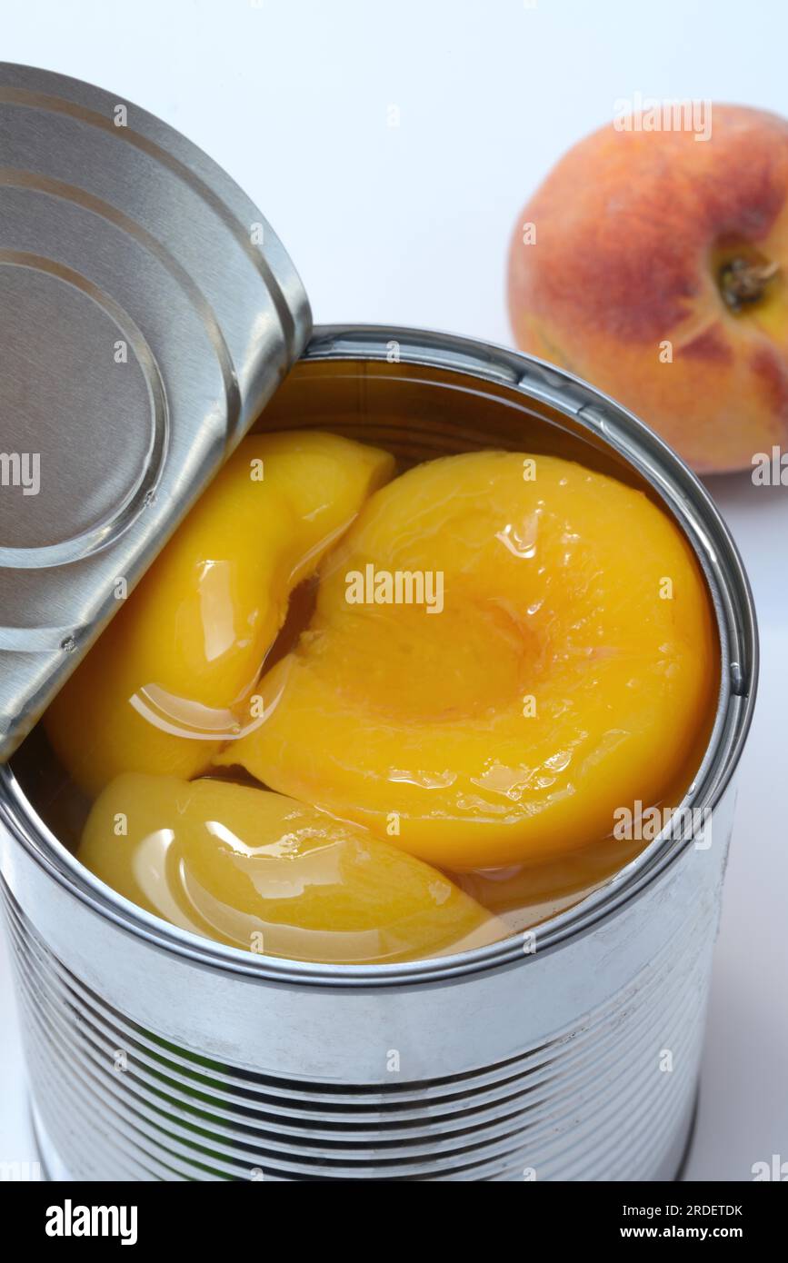Peach, preserved peach halves with syrup in a tin can Stock Photo - Alamy