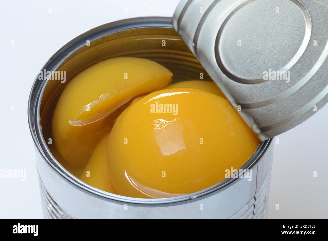 Peach, preserved peach halves with syrup in a tin can Stock Photo - Alamy