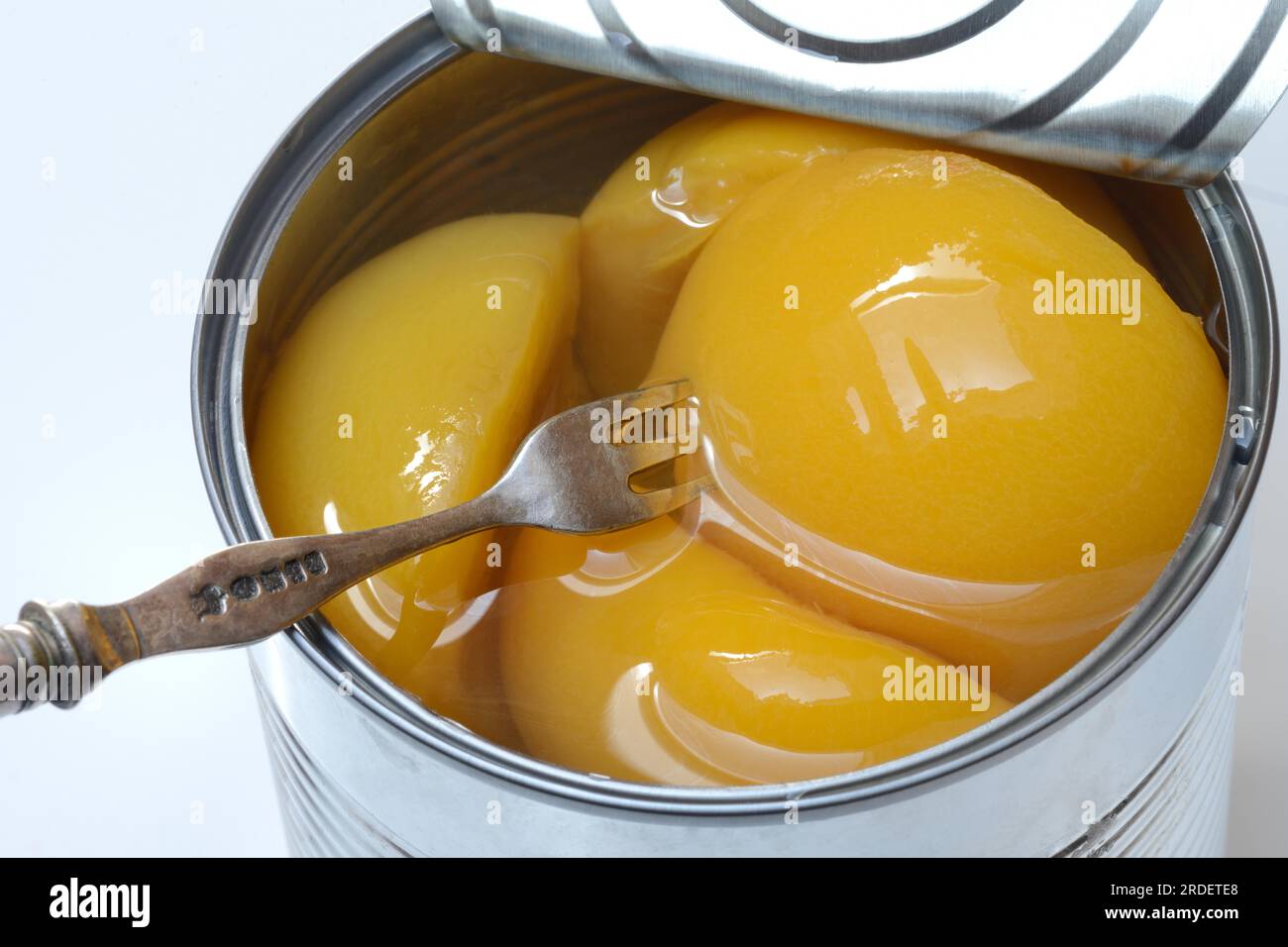 Peach, preserved peach halves with syrup in a tin can Stock Photo - Alamy