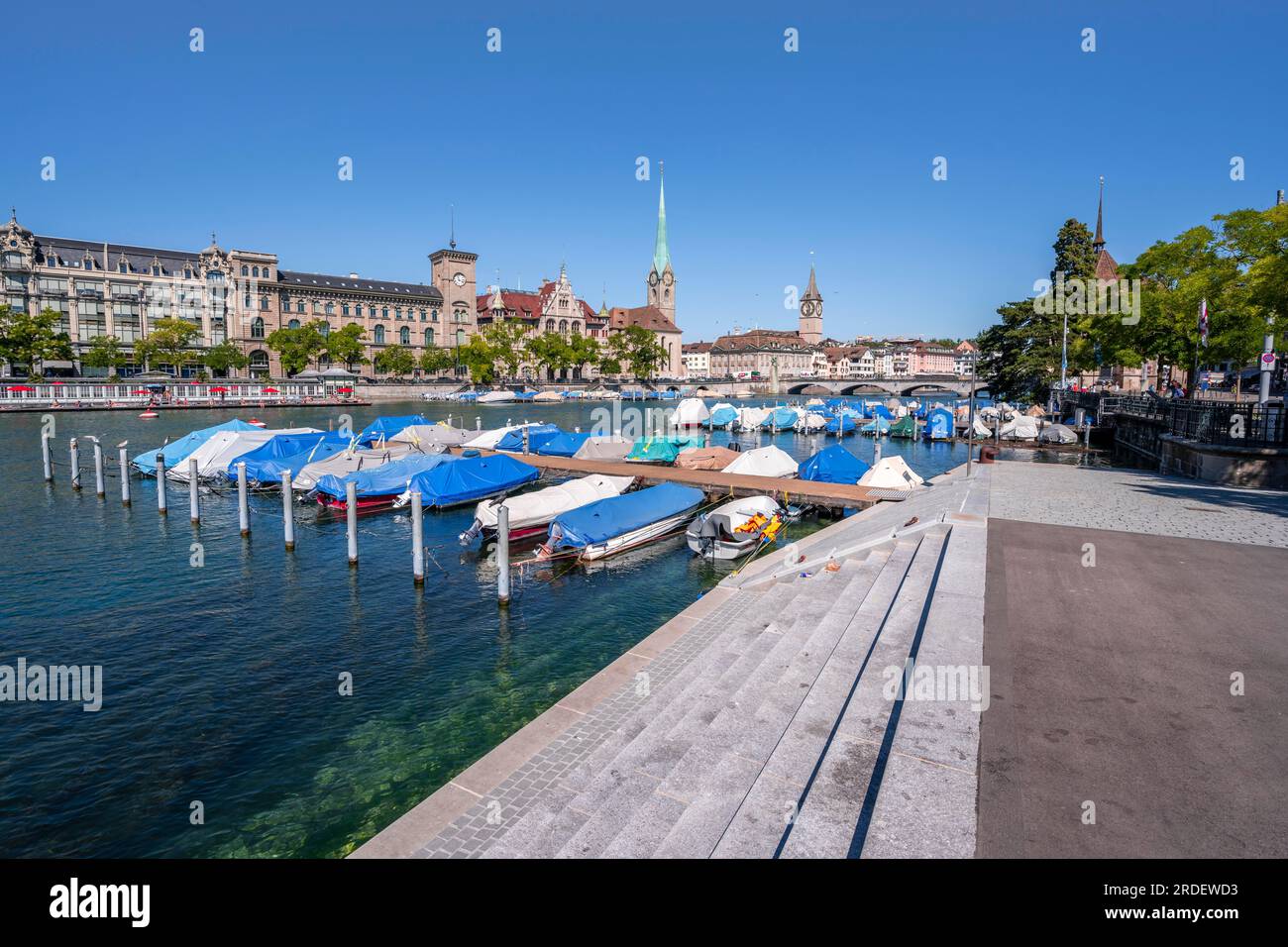 Boats at the jetty in the Limmat, towers of the Fraumuenster and St ...
