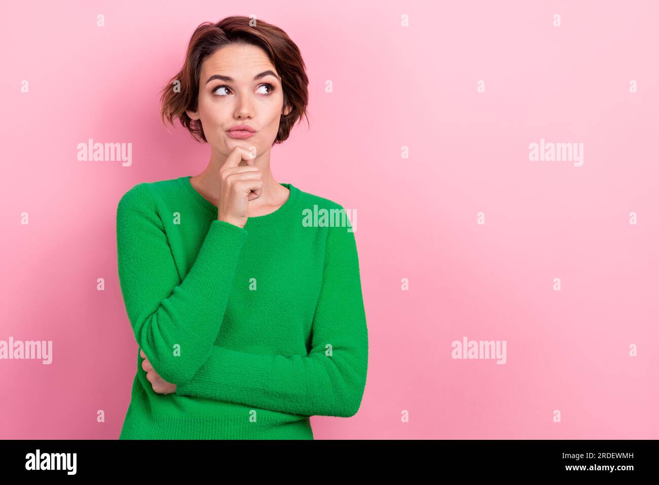 Portrait of thoughtful young girl hair wear green jumper touch chin ...