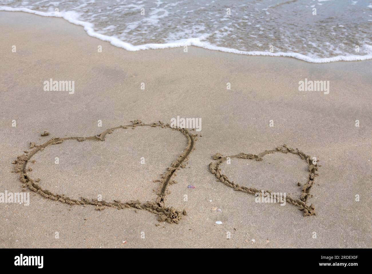 Hearts painted in the sand Stock Photo - Alamy