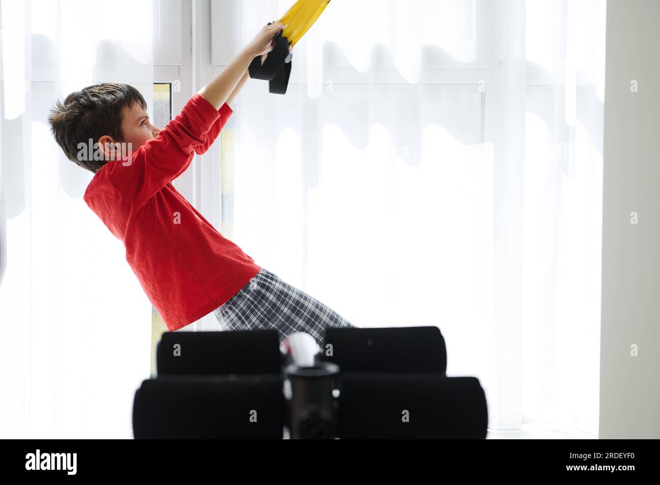 Side view of adorable Caucasian child, preteen boy exercising with ...