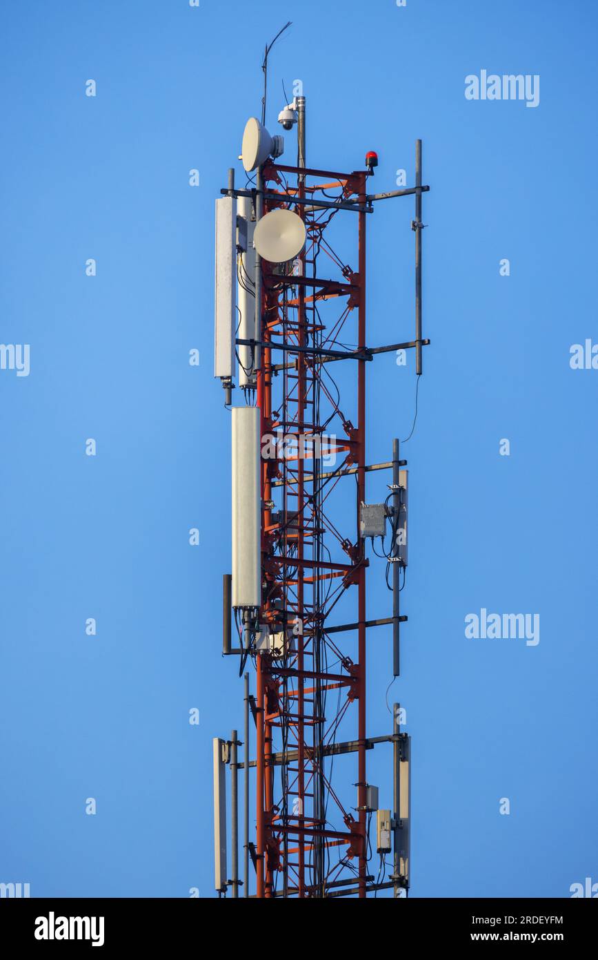 Telecommunication tower with radio devices is under blue sky on a ...