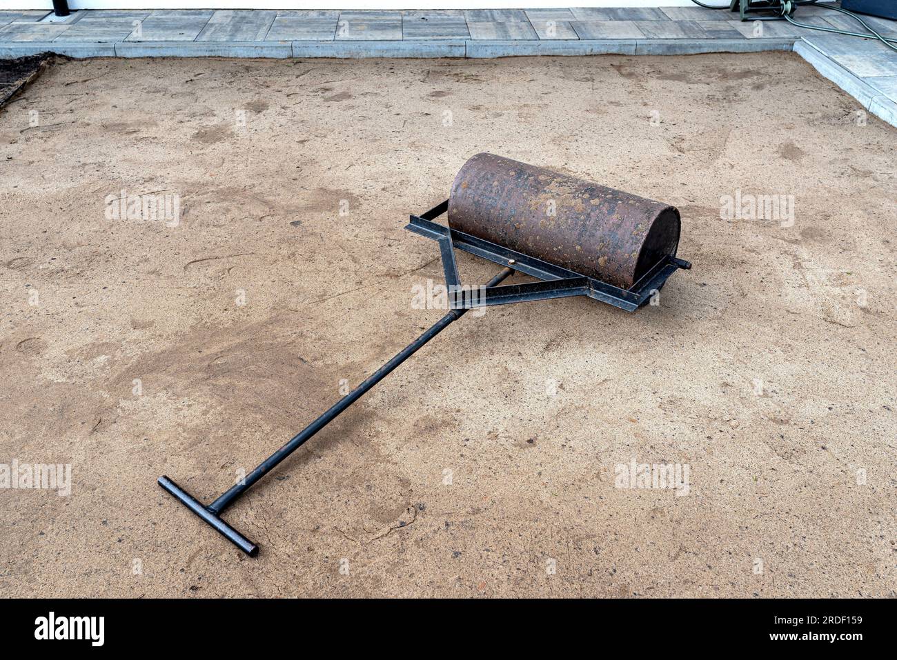 Rolling yellow sand with a steel roller for a garden pool Stock Photo ...