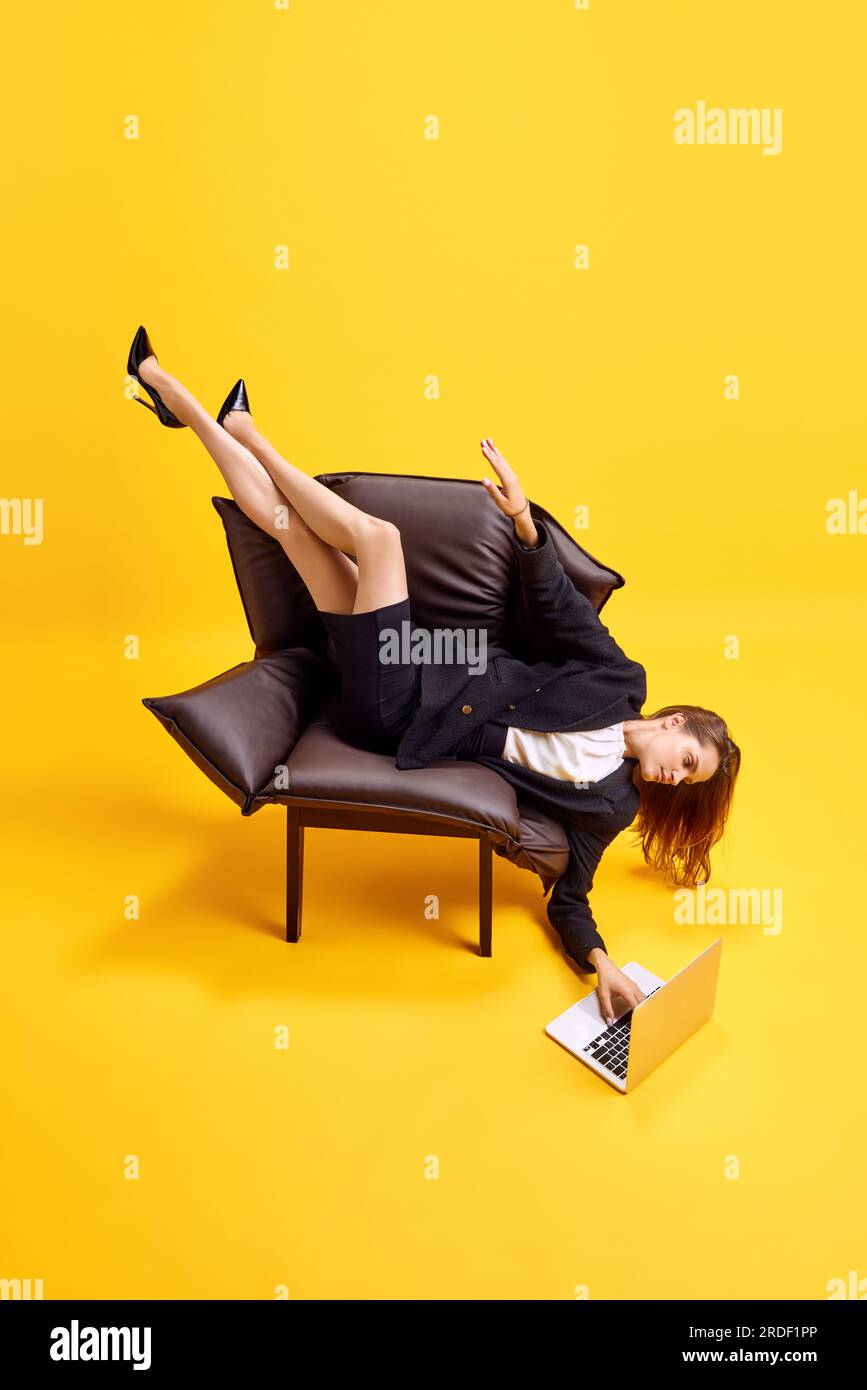 Young business woman lying on armchair in uncomfortable position ...