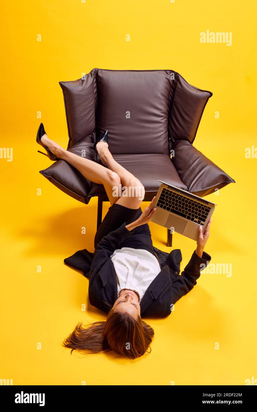 Young business woman, employee lying on floor near chair and working ...