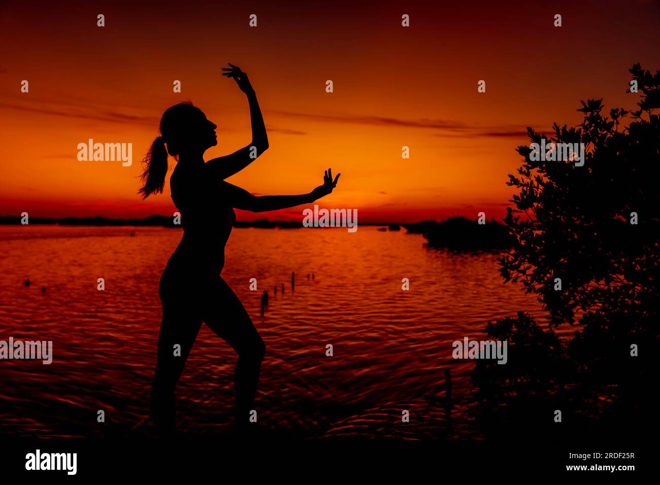 A gorgeous latin model poses as the sun rises over the Gulf of Mexico ...