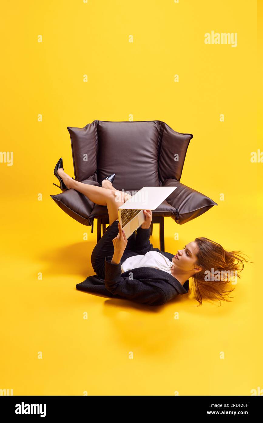 Young business woman, employee lying on floor near chair and working ...