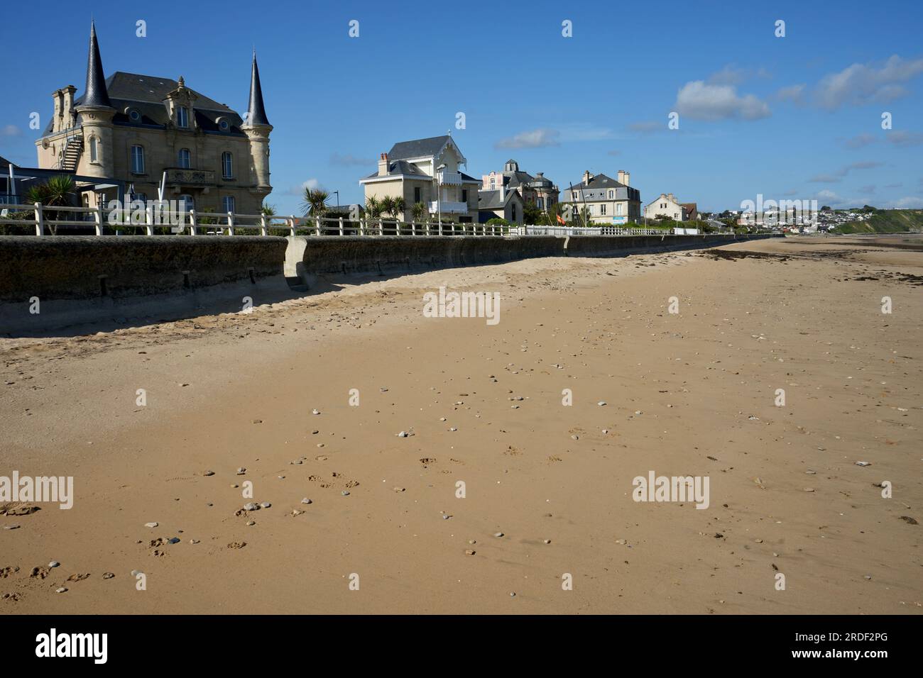 Beach with buildings behind and blue sky with white clouds. Asnelles ...