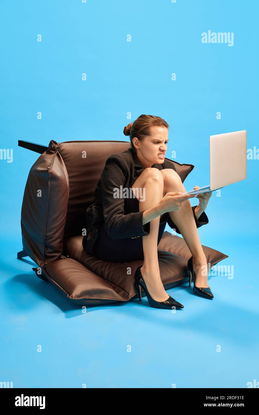 Irritation. Business Woman sitting on fallen armchair, looking on ...