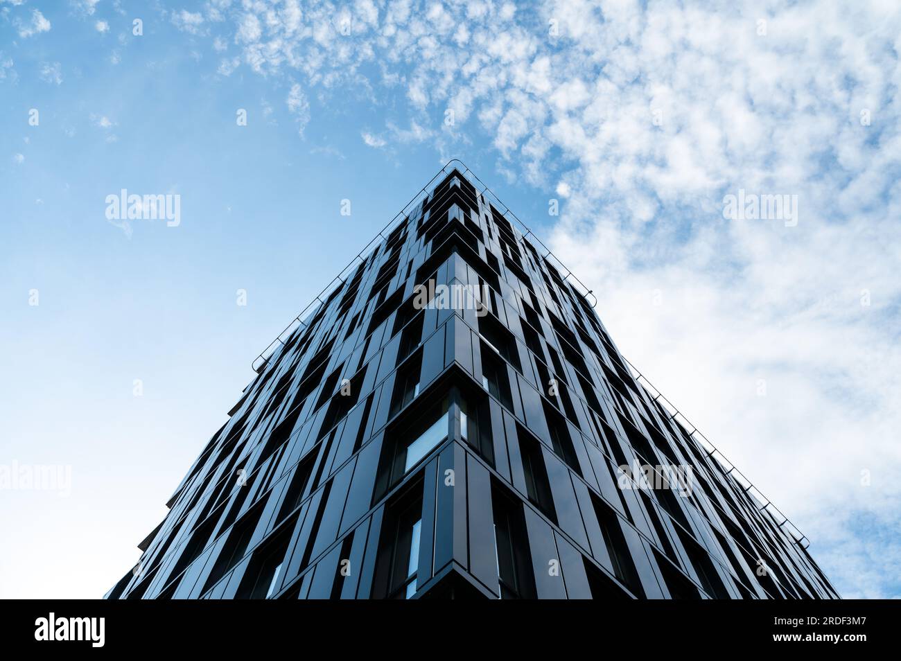 View from below to black skyscraper and sky with white clouds Stock ...