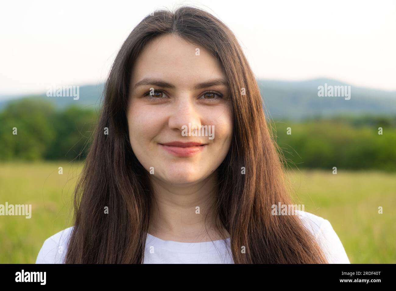 Portrait of a 30-year-old brunette woman looking at the camera smiling ...