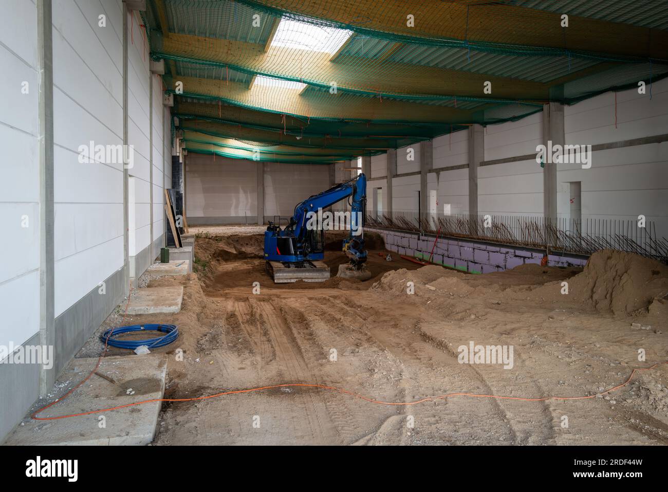 the ground of a newly built factory hall is excavated with an excavator ...