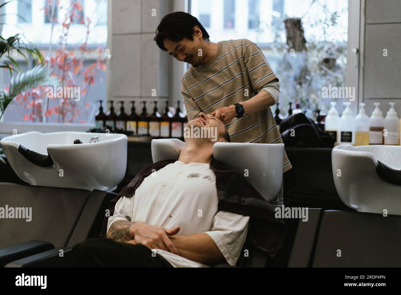 Hairstylist washing hair to handsome man in beauty salon Stock Photo ...
