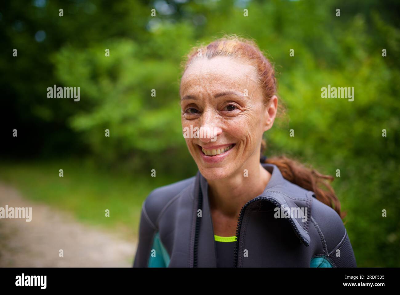 Portrait of a smiling red-haired woman in a wetsuit Stock Photo - Alamy