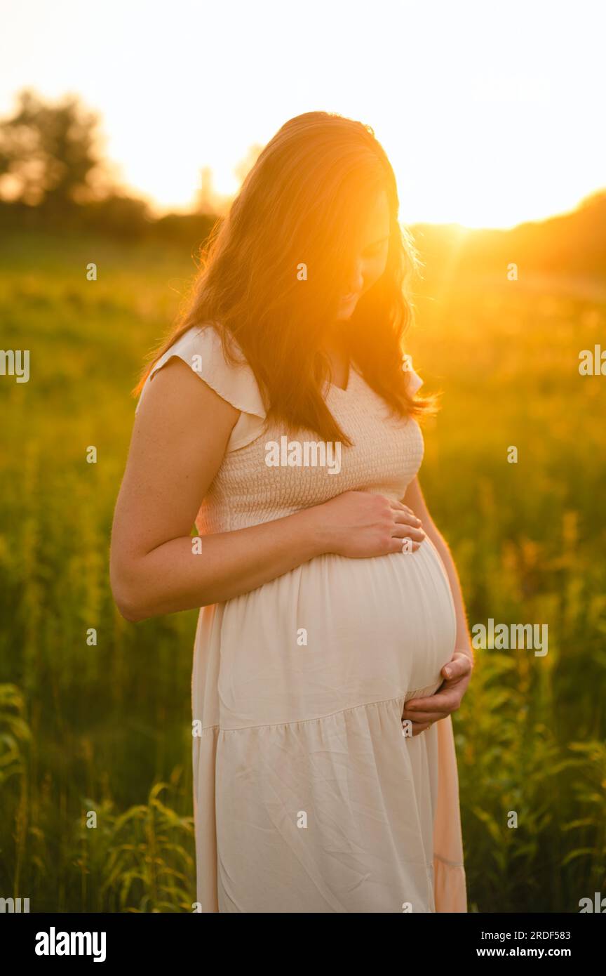Maternity photos of pregnant mom holding baby bump outdoors in nature ...