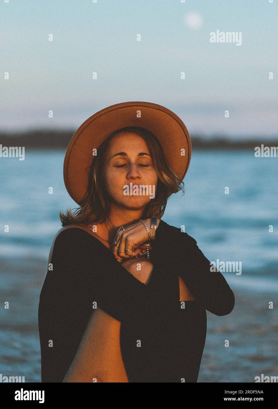 Young Woman By The Ocean Under The Full Moon Stock Photo - Alamy