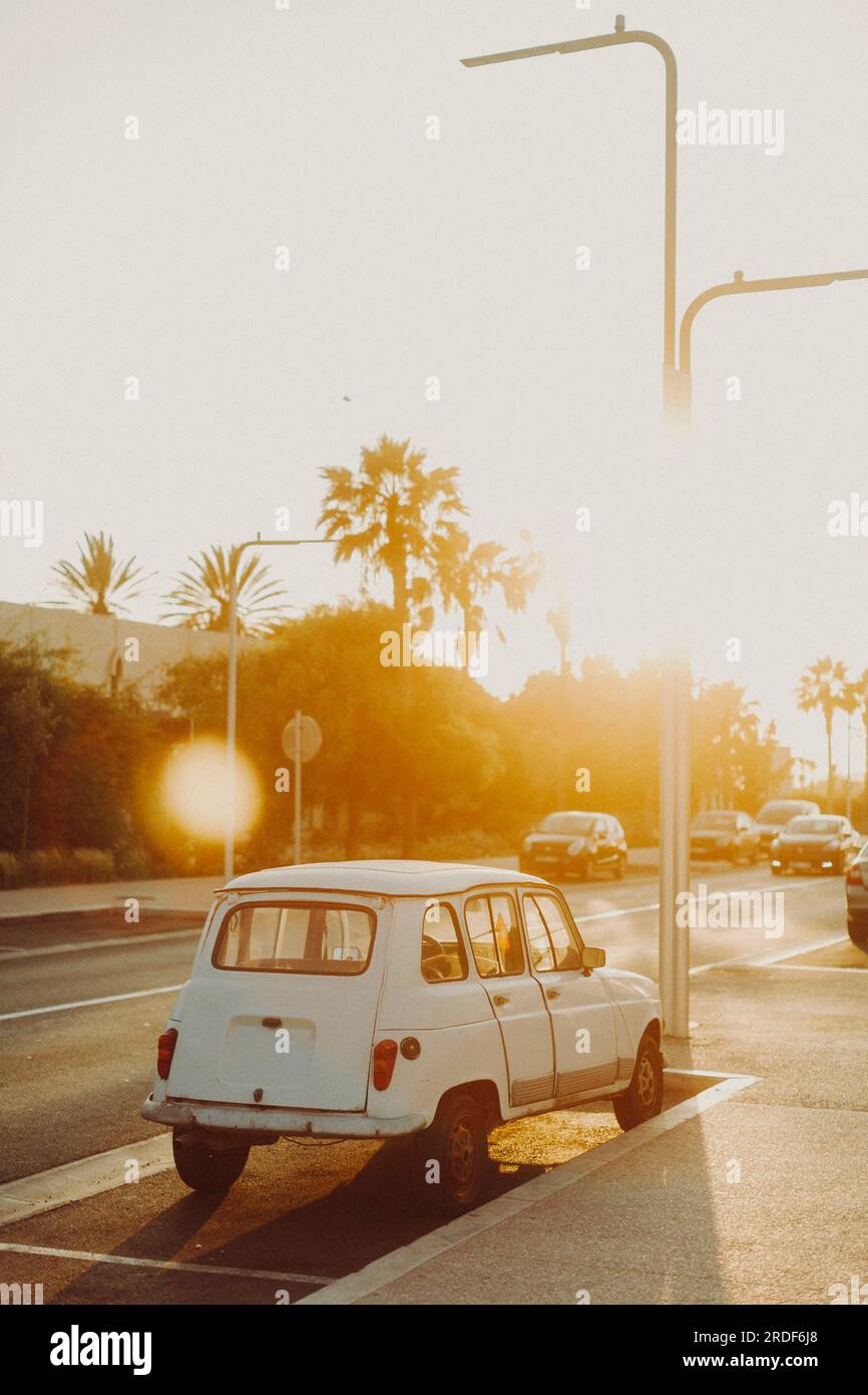 A vintage white car is backlit by the setting sun in Morocco Stock ...