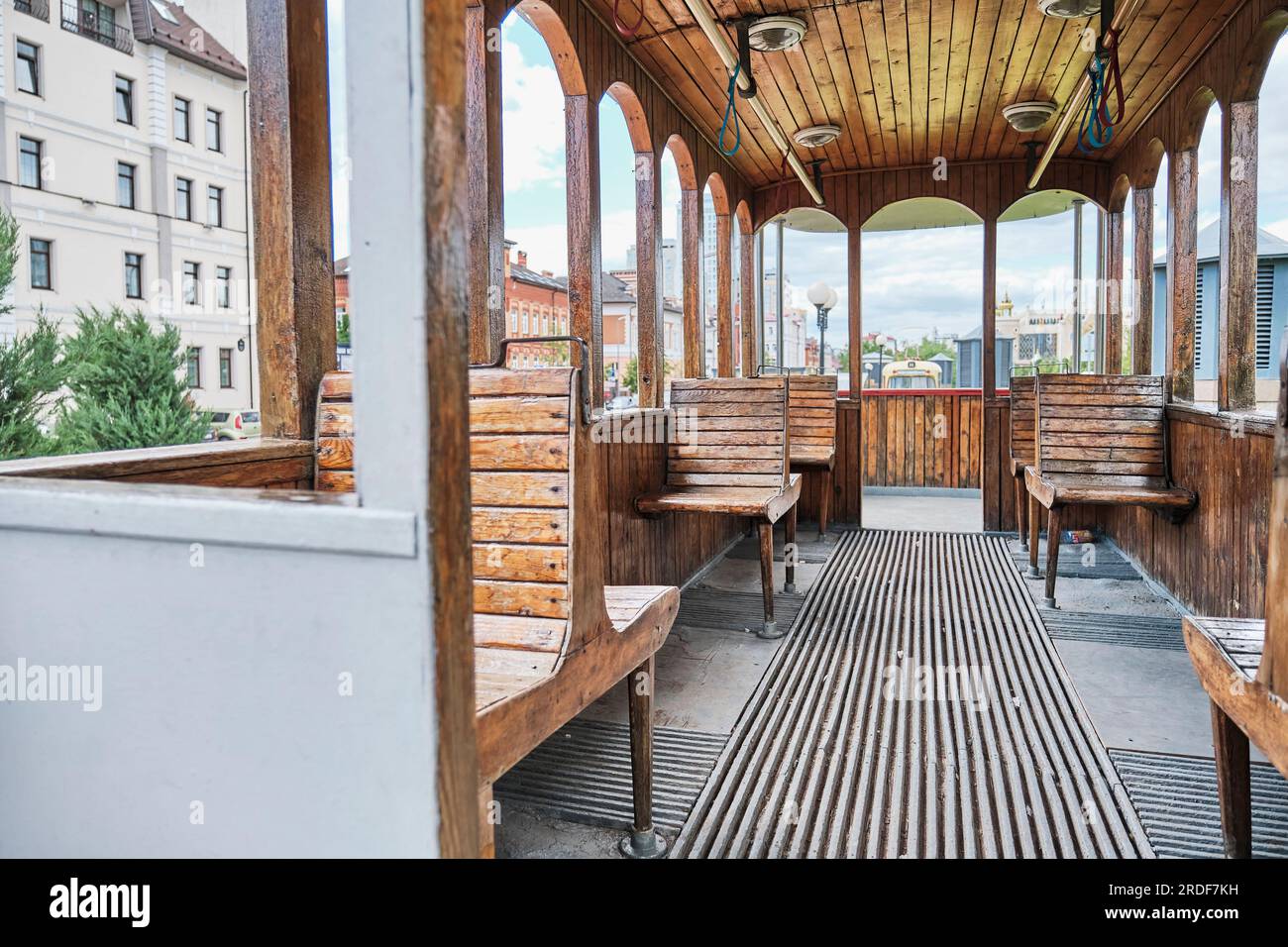 Interior of retro tram with wooden trim and seats. Two-axle motor tram ...