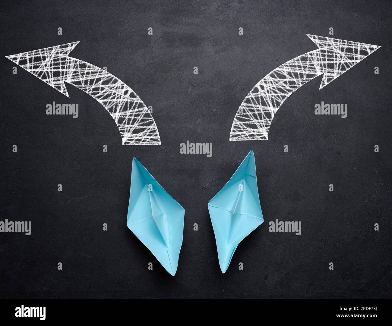 Two paper boats are moving in different directions on a black ...