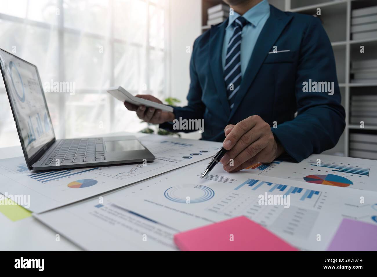 Closed up young business man read write doing report figure paper chart ...