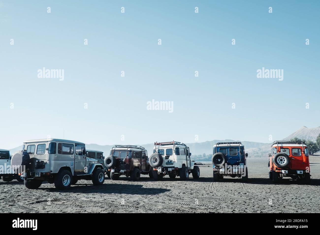 A lot of off-road vehicles or full-sized SUVs are parked in the desert ...