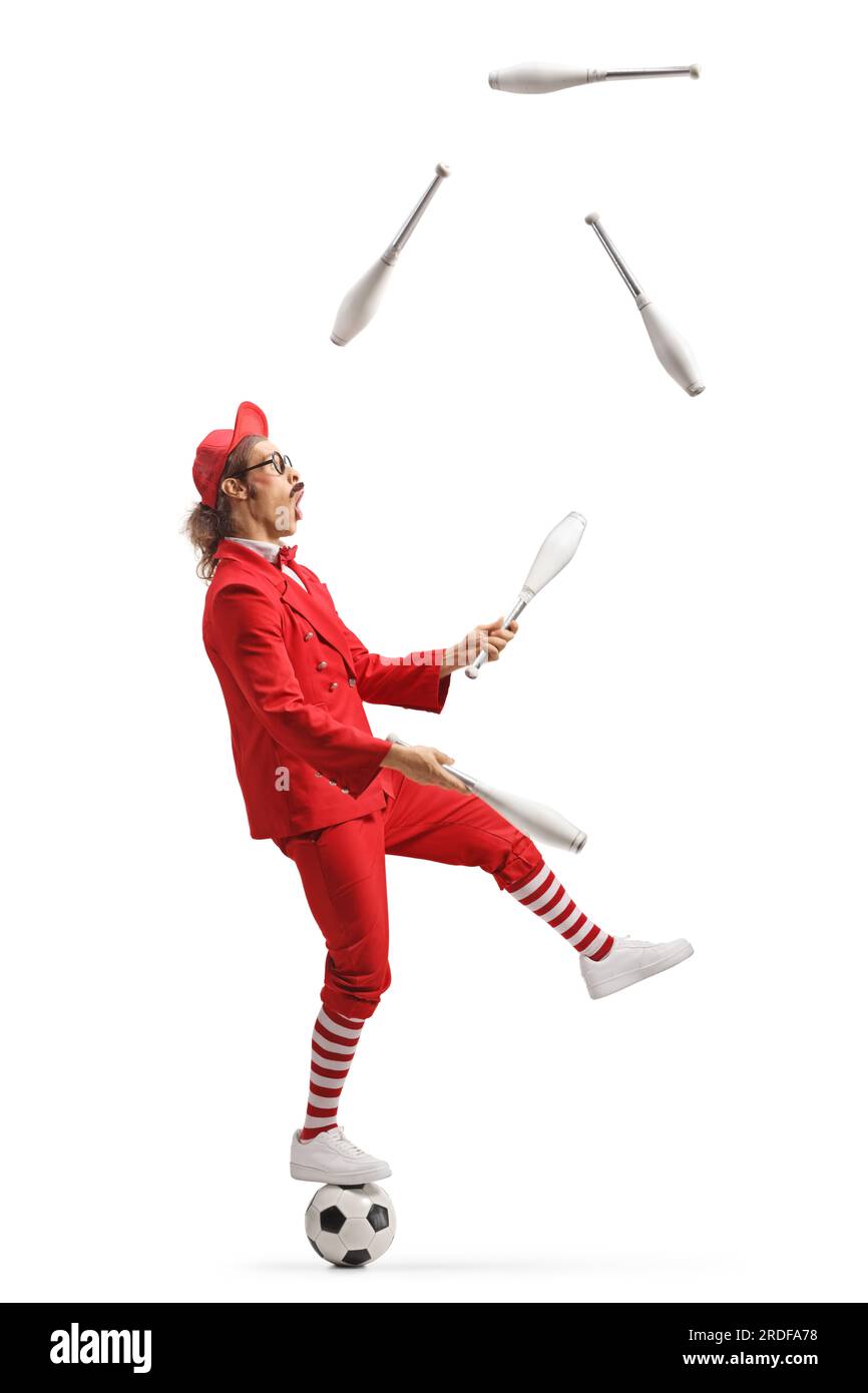 Man in a red suit standing on a football and juggling isolated on white ...