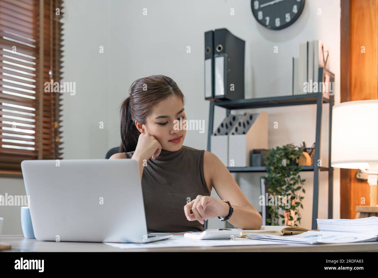 Stressed and bored young woman checking bills, taxes, bank account ...