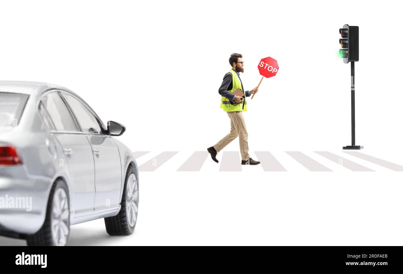 Full length shot of a man carrying books and a stop sign on a street in ...