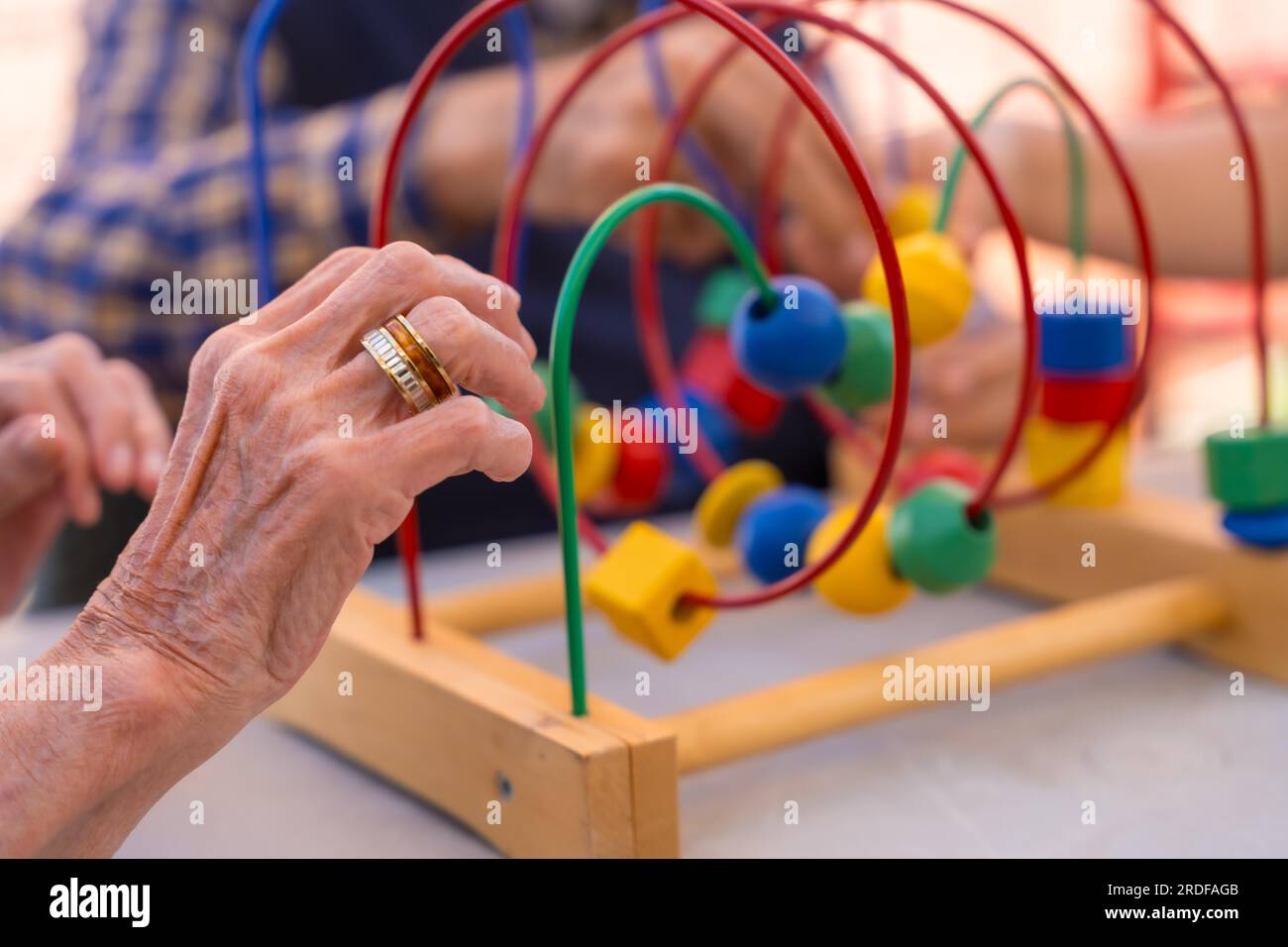 Hands of two elderly people in the garden of a nursing home or ...
