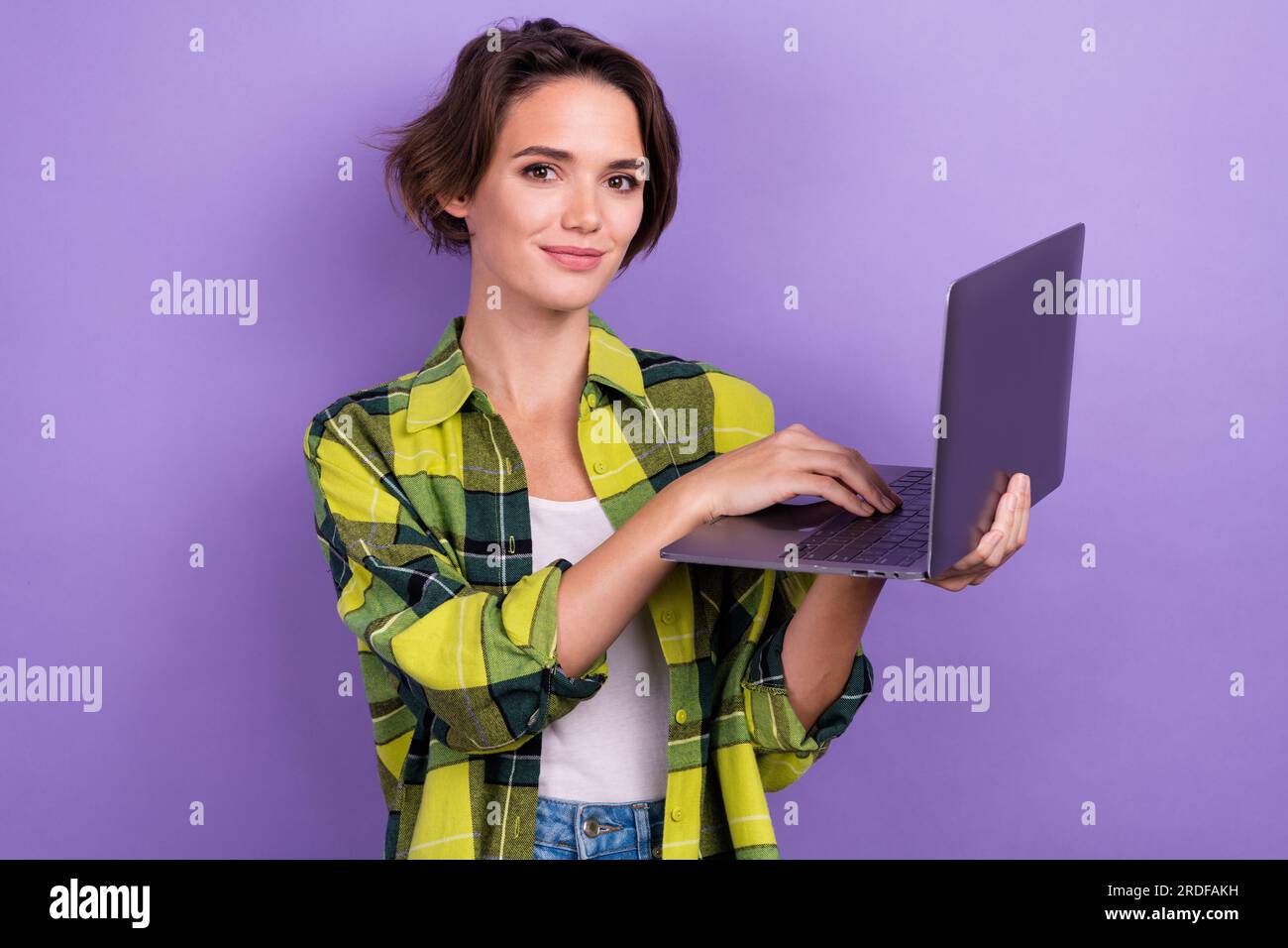 Photo of young model girl wearing green plaid jacket holding netbook it ...