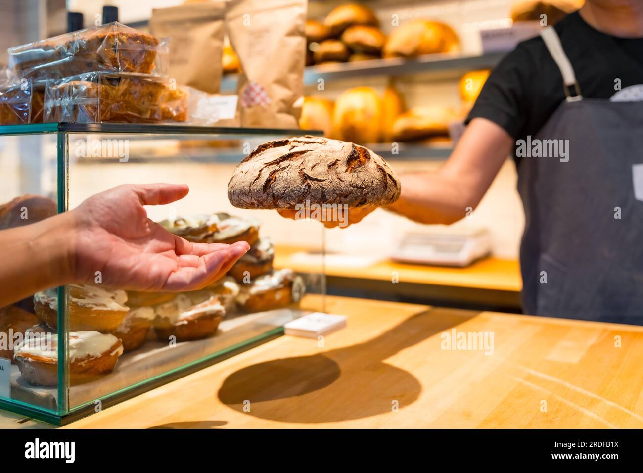 Customer hands in the bakery shop buying an artisan bread from the ...