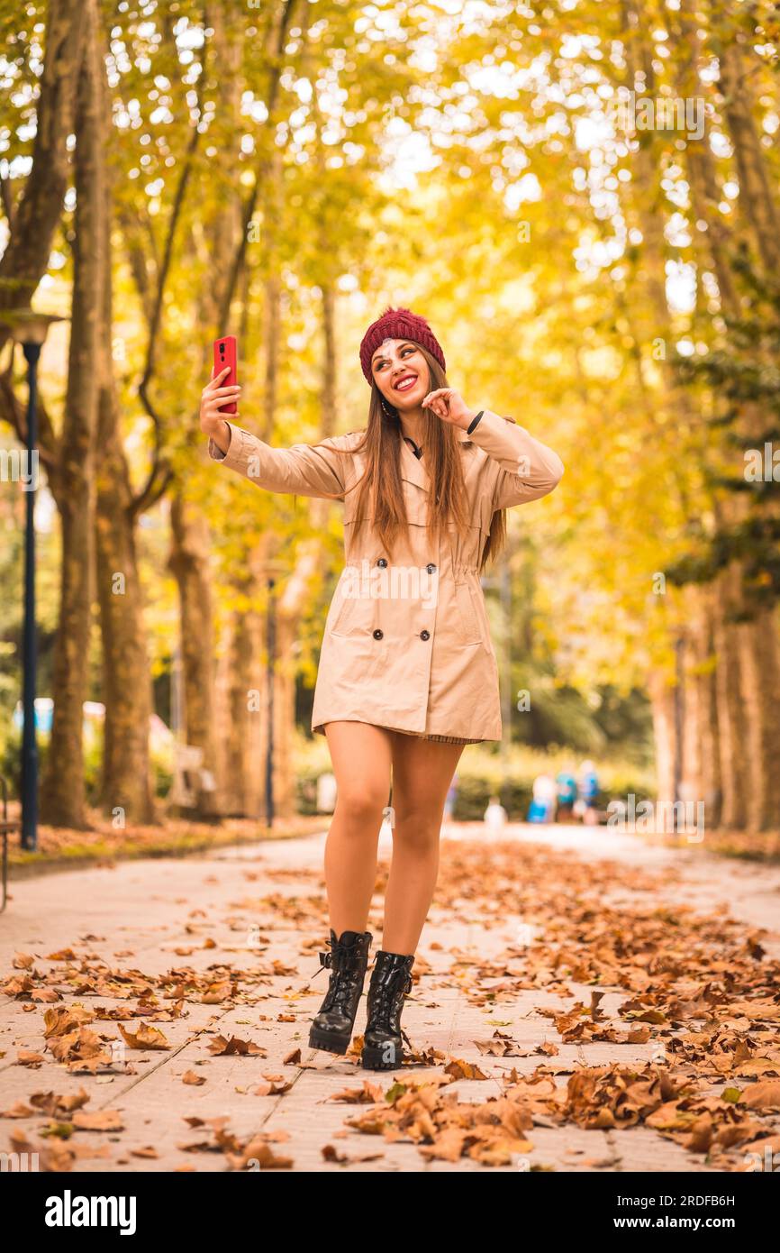 Portrait of a beautiful woman in autumn next to a forest in nature ...