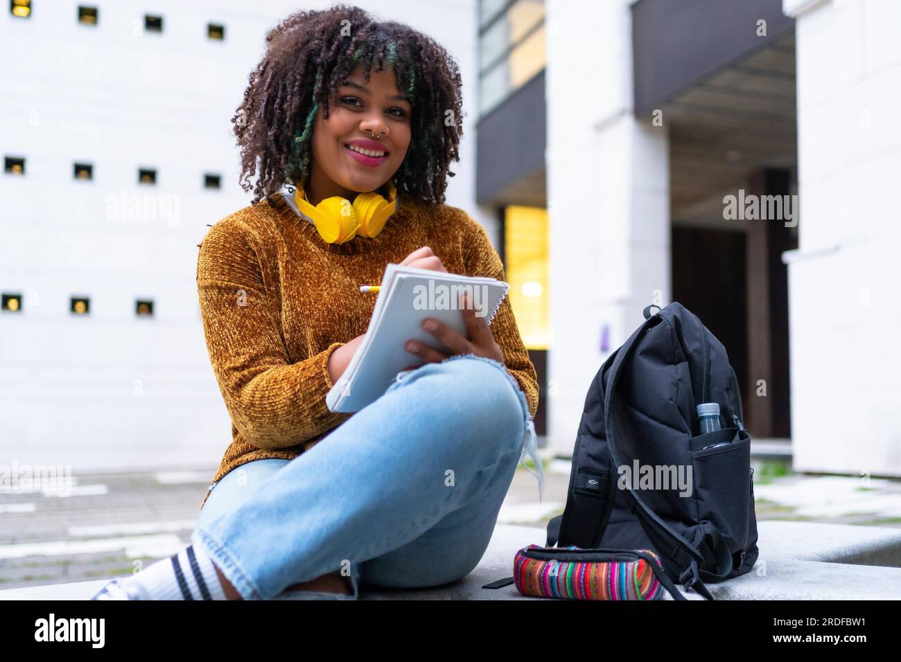 Portrait of black ethnic girl sitting in college doing class work Stock ...