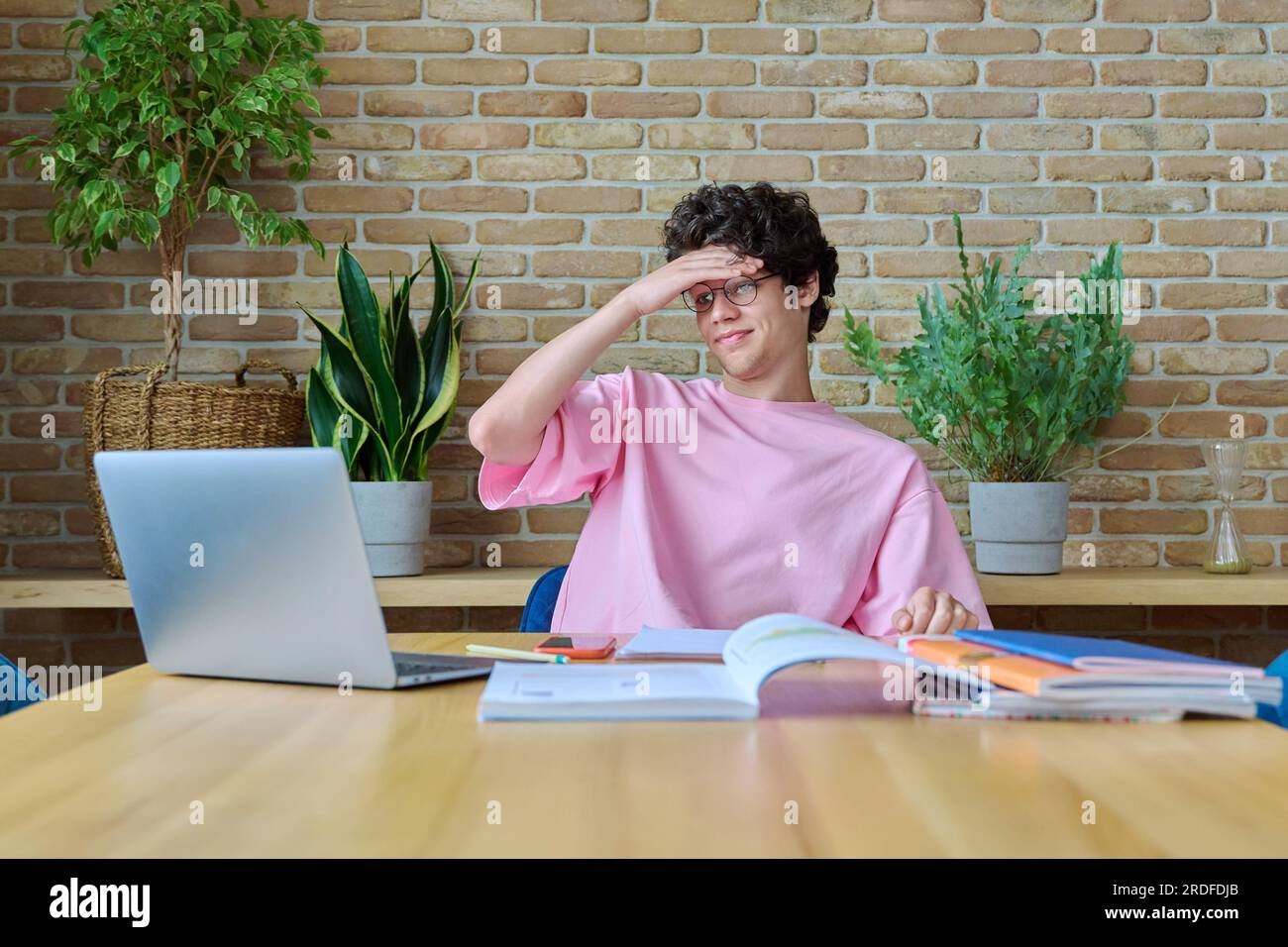 Tired sad guy student sitting at desk at home with laptop Stock Photo ...